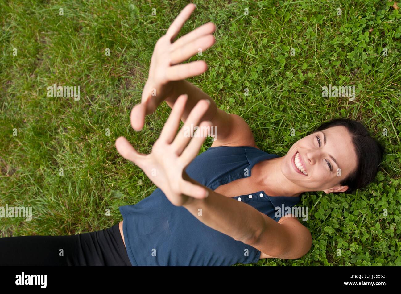 woman hand hands person lie lying lies down above meadow grass lawn ...