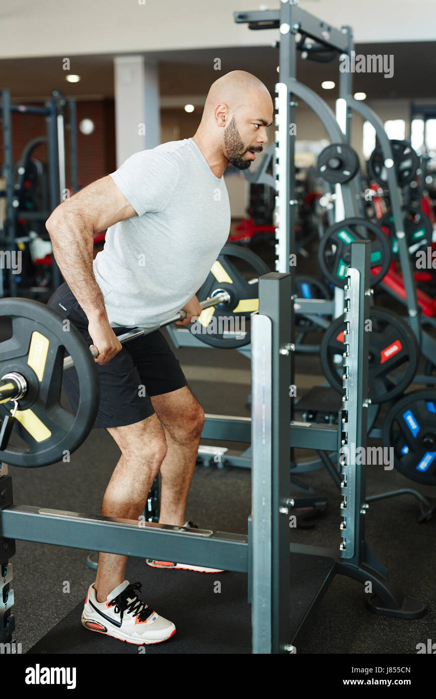 Strong man lifting heavy weight in gym Stock Photo - Alamy
