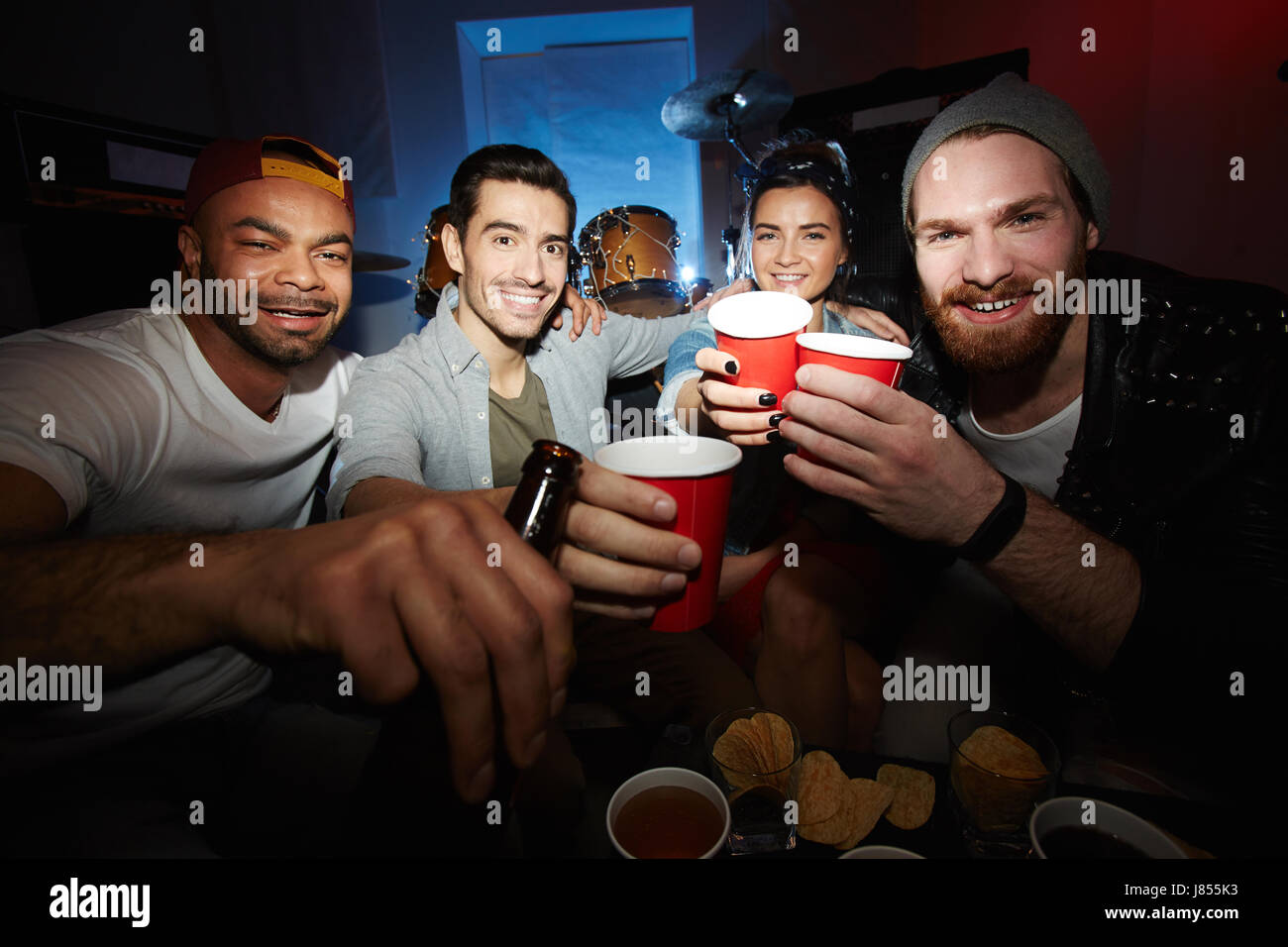 Toasting friends looking at camera at party Stock Photo - Alamy