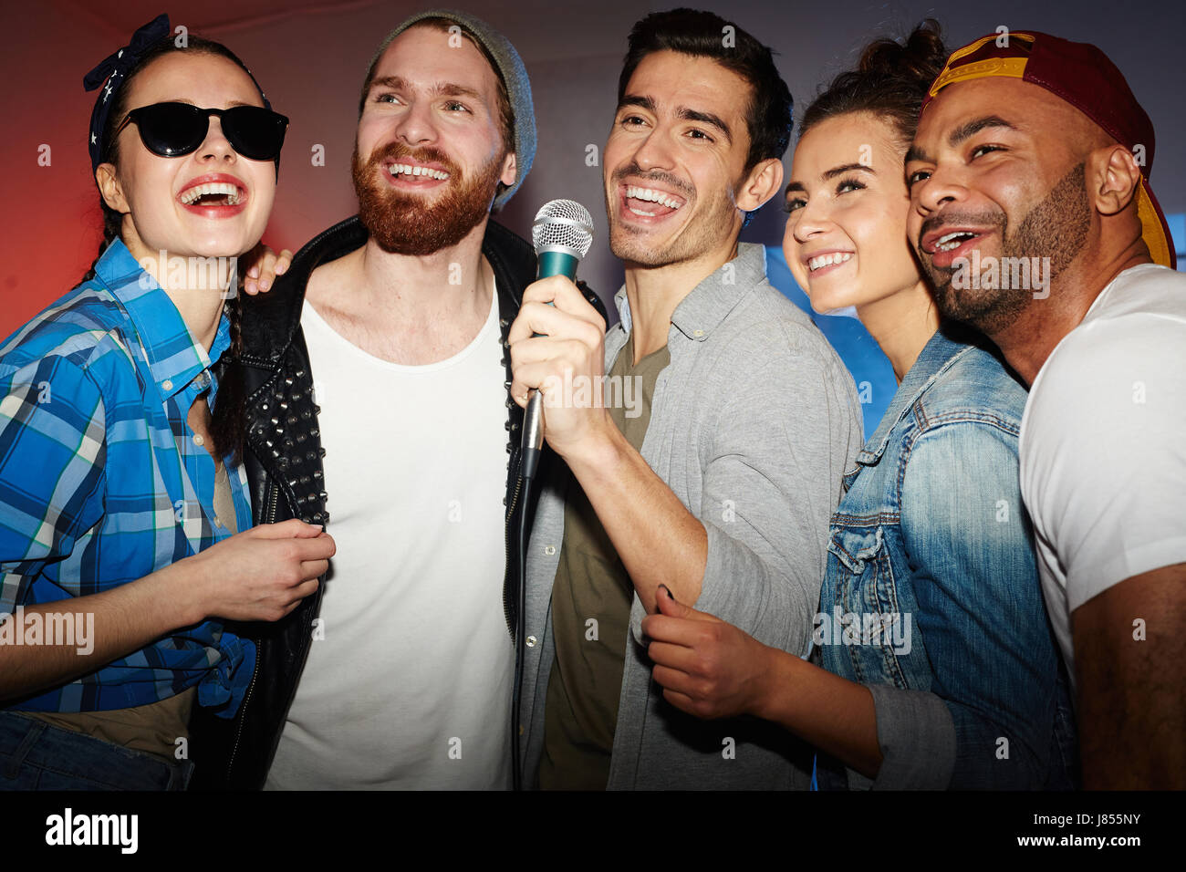 Happy friends singing karaoke party hi-res stock photography and images ...