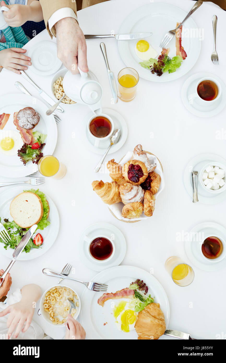 Human hands over served table during family breakfast Stock Photo - Alamy