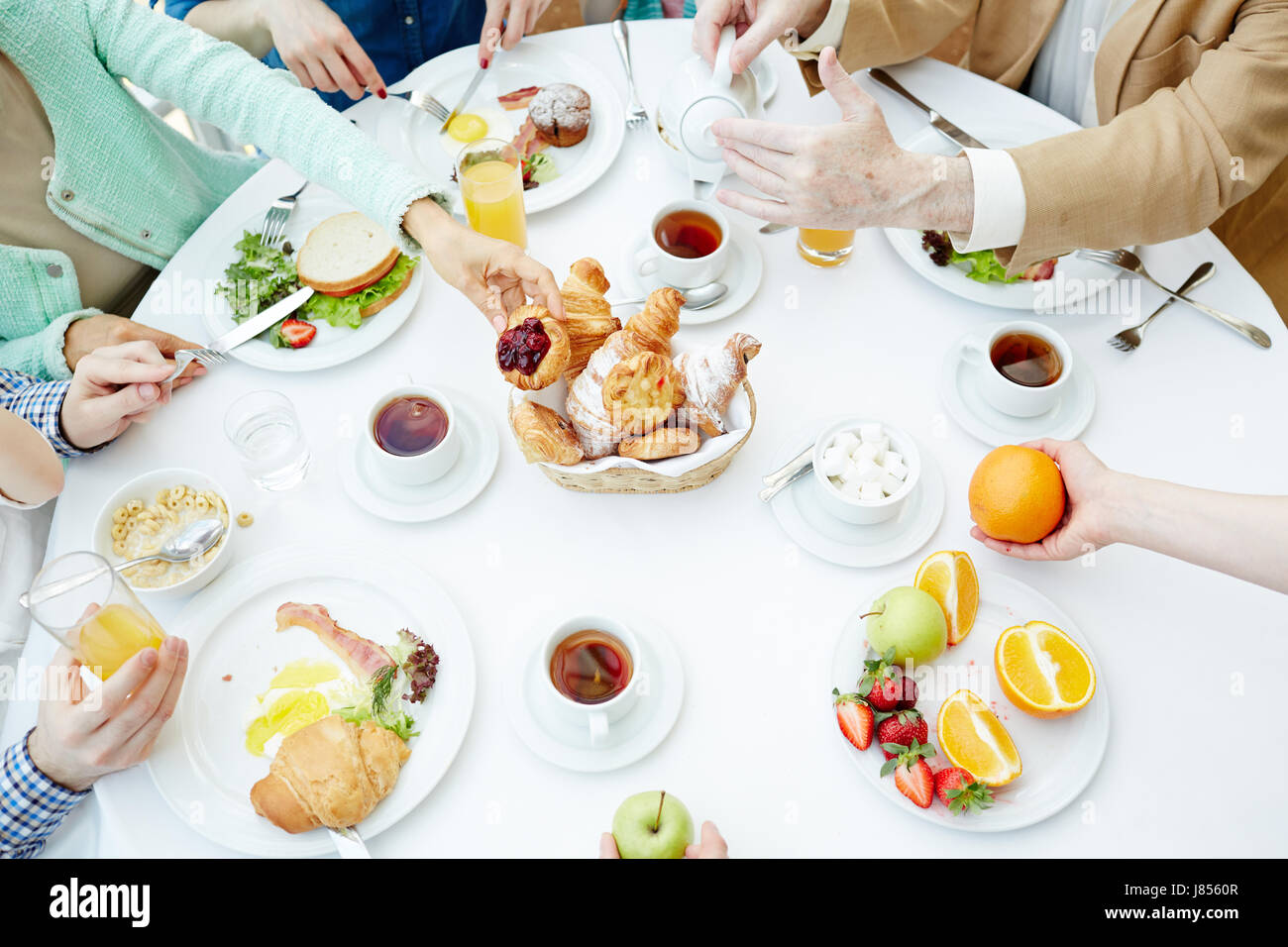 Served table with fresh food and human hands during breakfast Stock ...