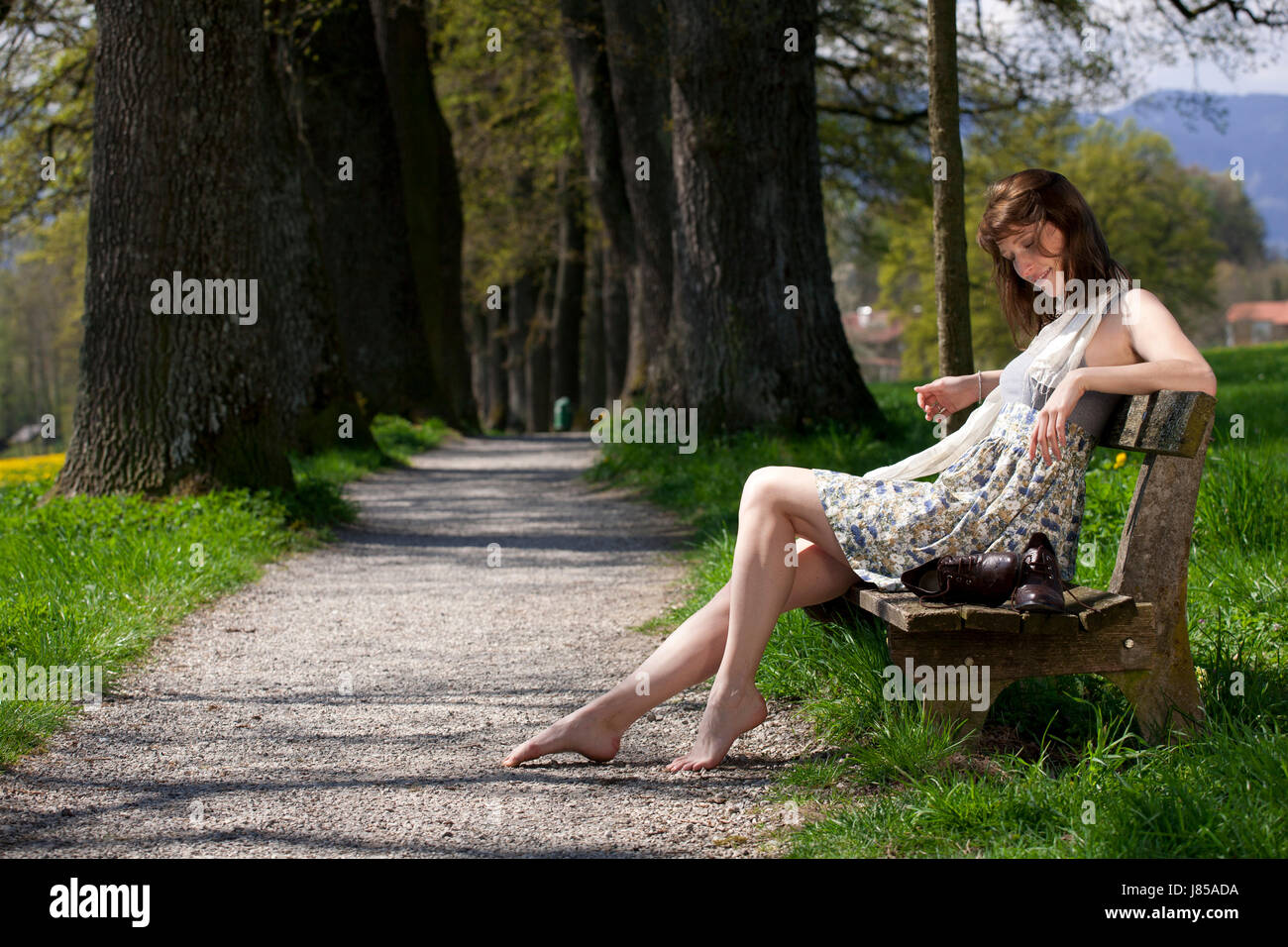 woman spring barefoot young younger seat bench park bench enjoying ...