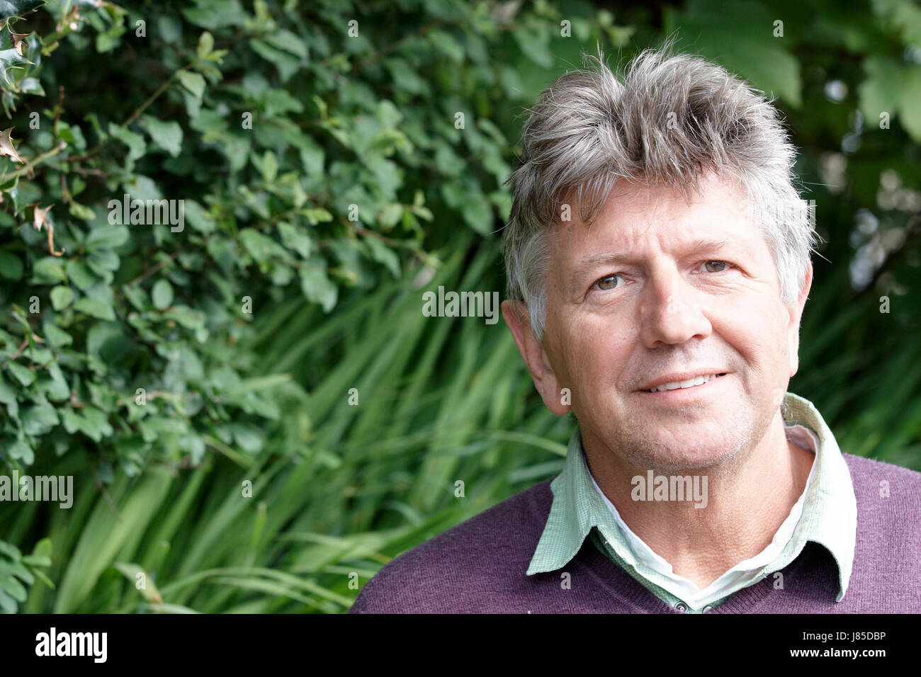male masculine portrait shoulders blur meadow grass lawn green outdoors ...