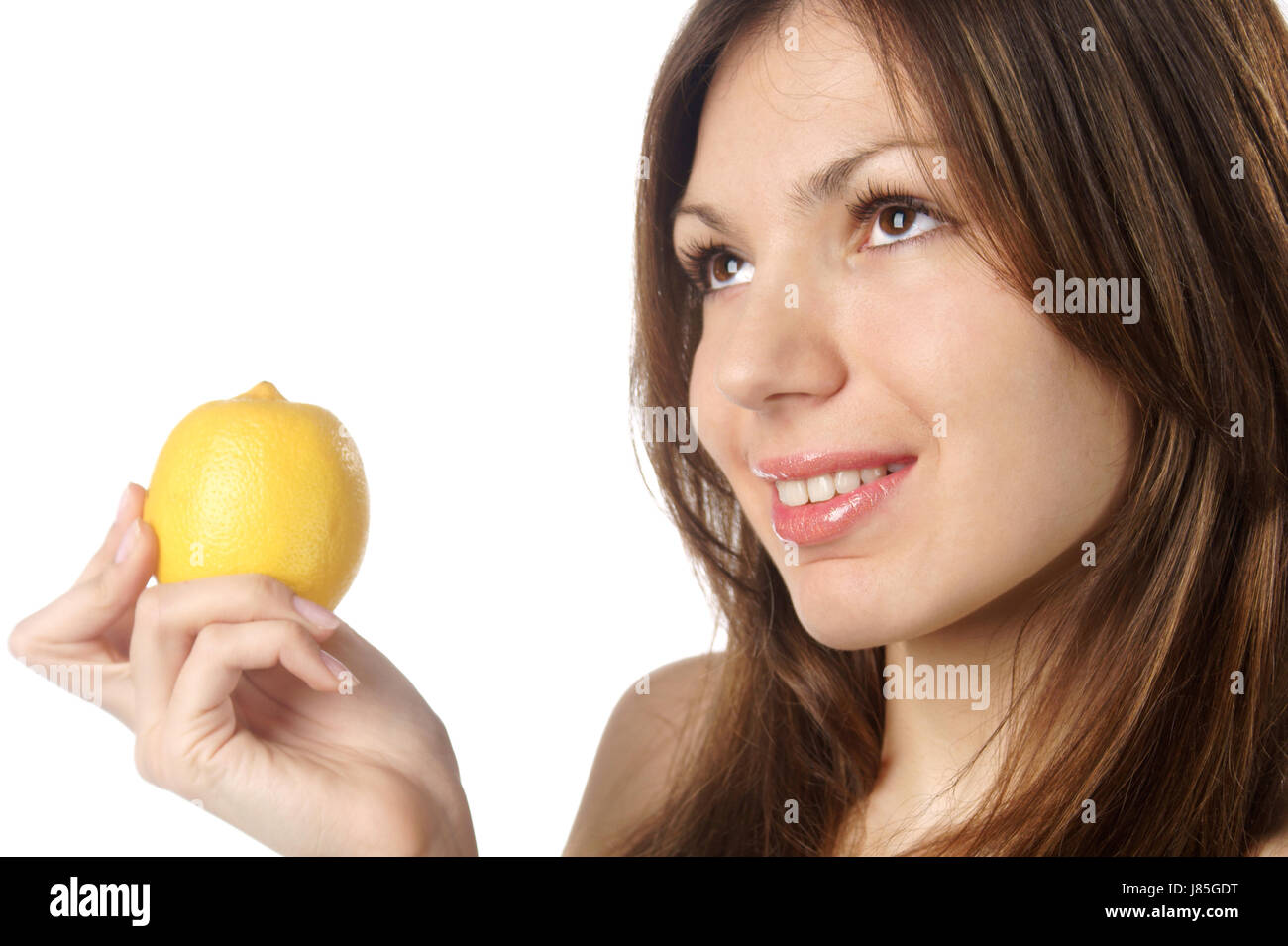 studio portrait of beautiful young woman with lemon against white ...