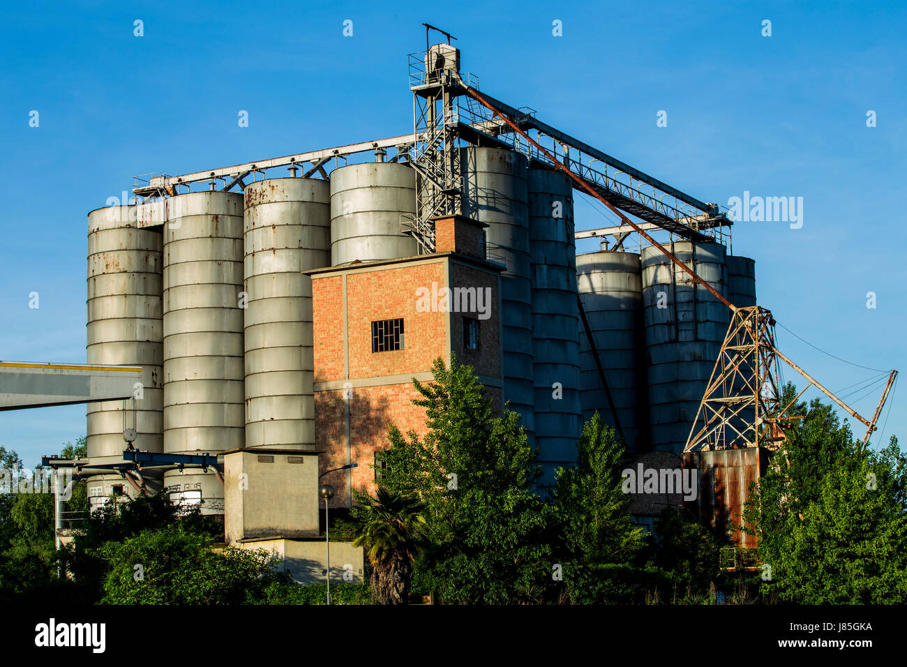 Silos, factory on blu sky in background Stock Photo - Alamy
