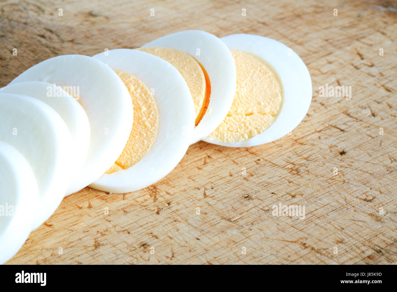 Sliced hard boiled egg on wooden surface Stock Photo - Alamy