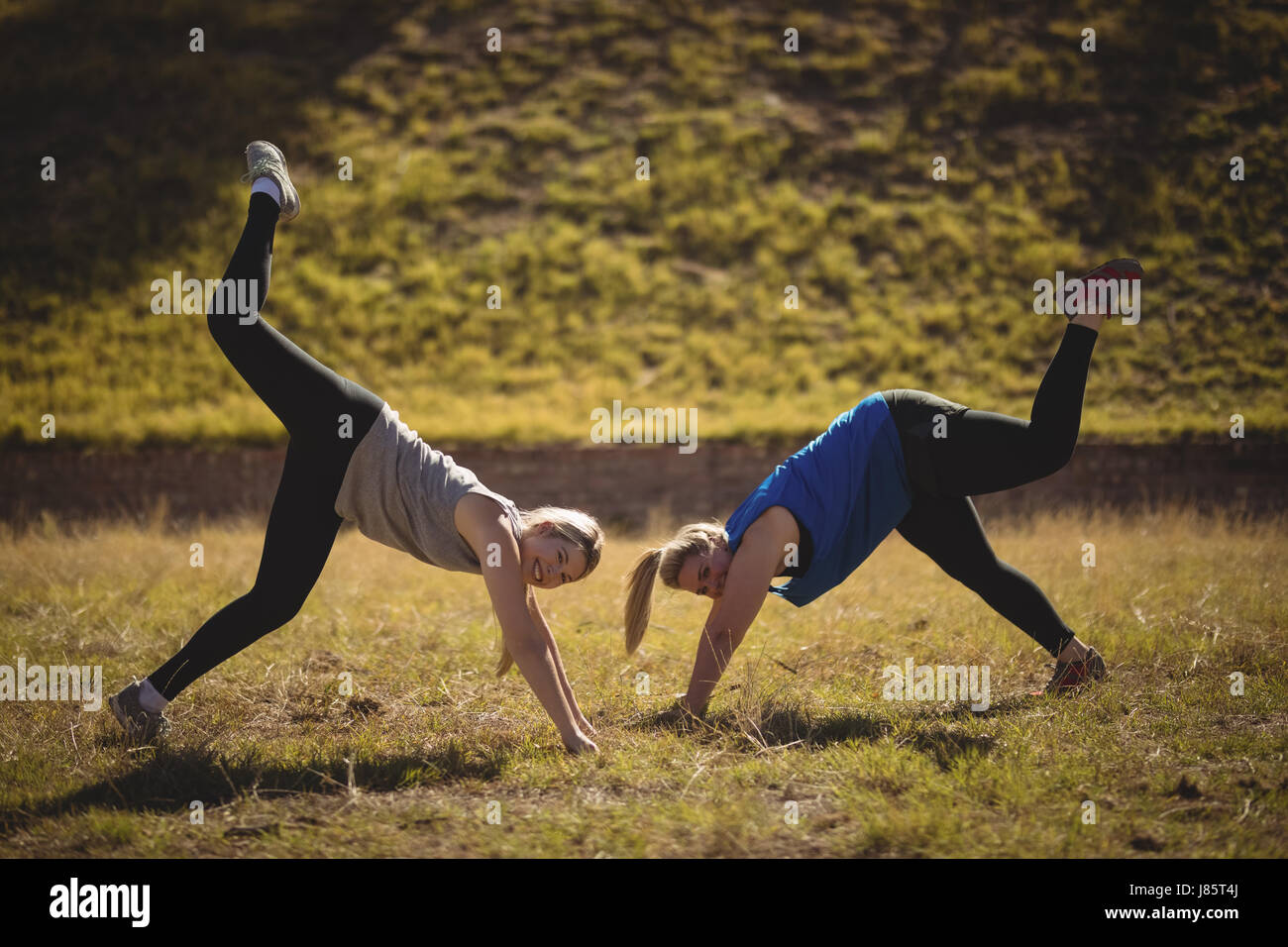 Portrait of beautiful women praising yoga during obstacle course in ...