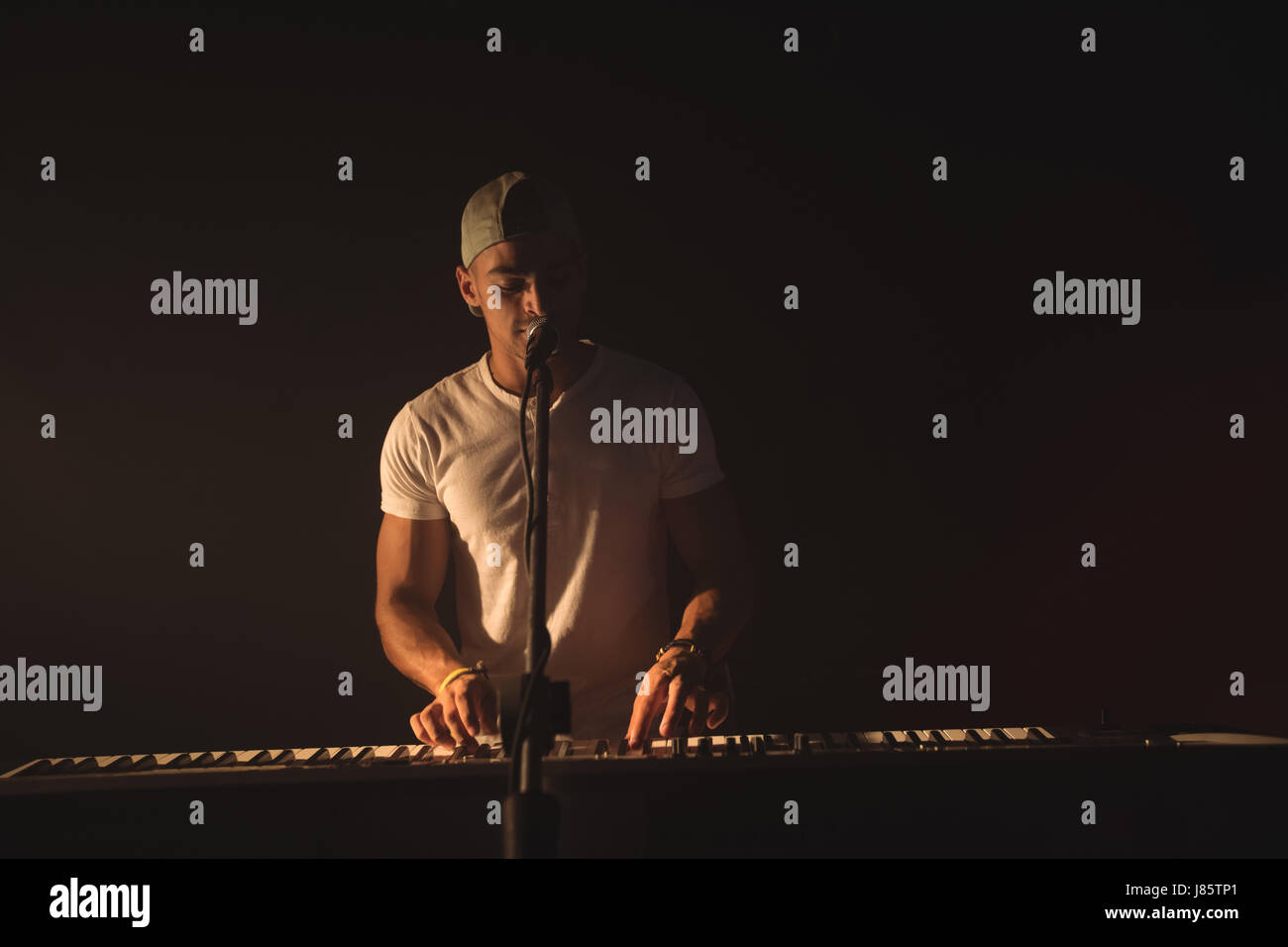 Young male singer playing piano at music concert Stock Photo - Alamy
