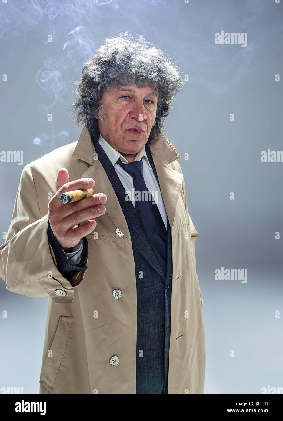 The senior man with cigar as detective or boss of mafia on gray studio ...