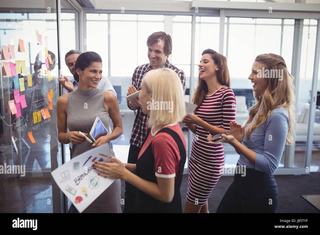Cheerful business people making plans with adhesive notes in creative ...