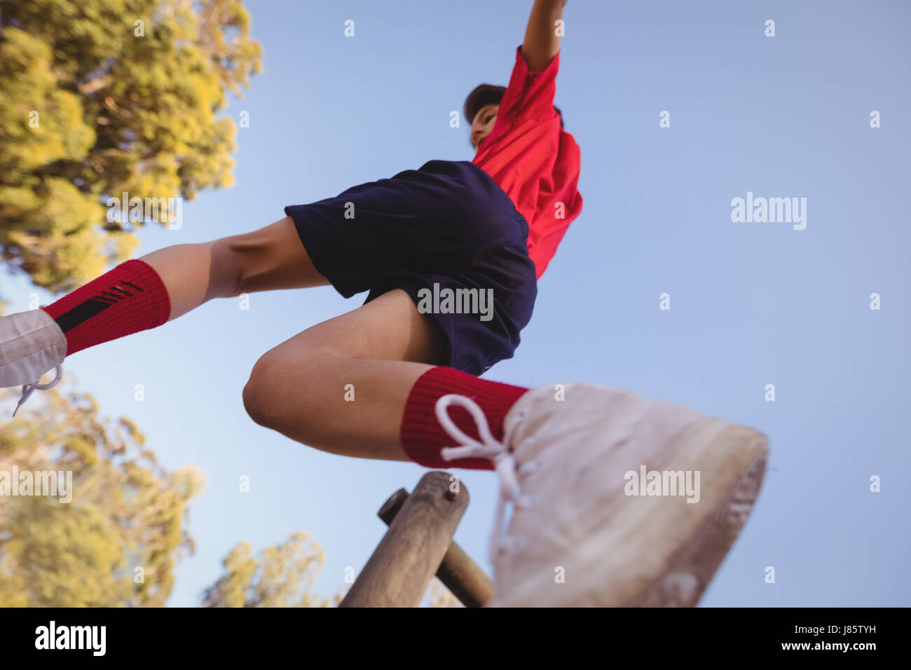 Determined boy jumping over obstacle in boot camp Stock Photo - Alamy
