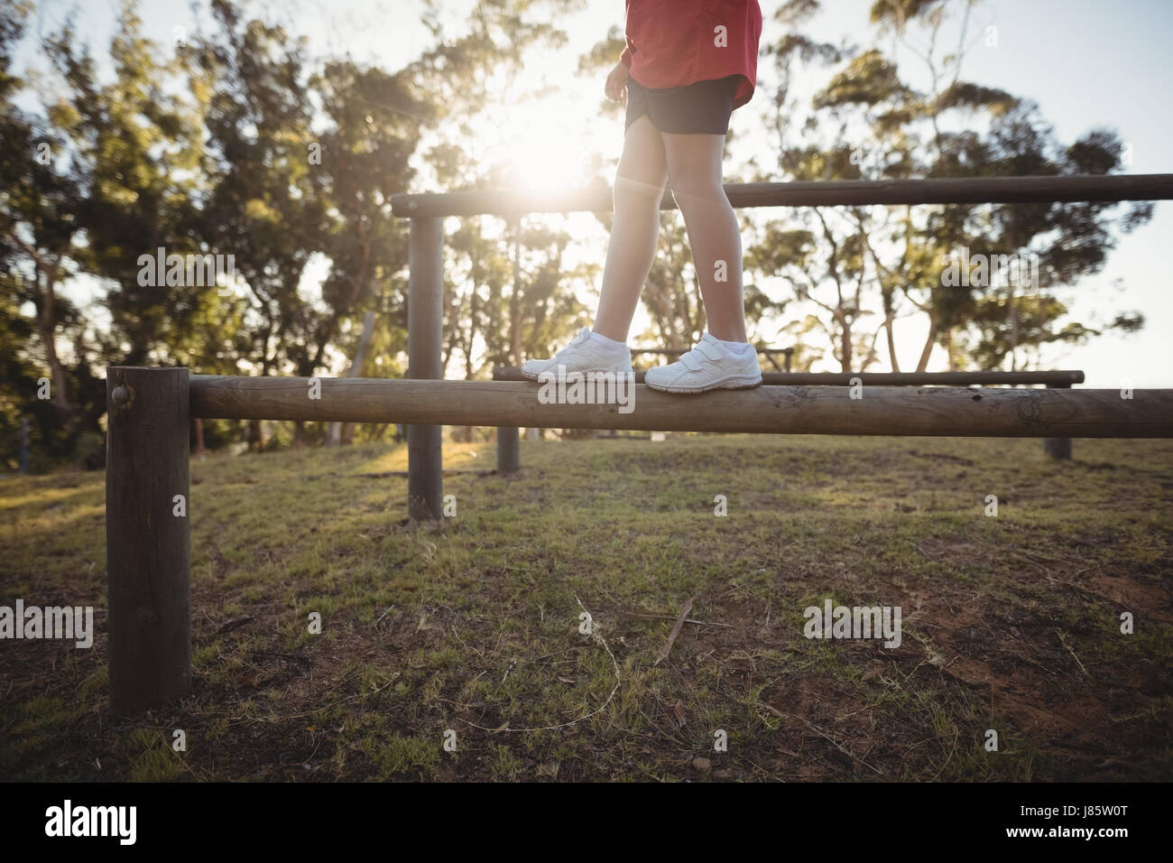 Low section of kid walking on obstacle during obstacle course in boot ...