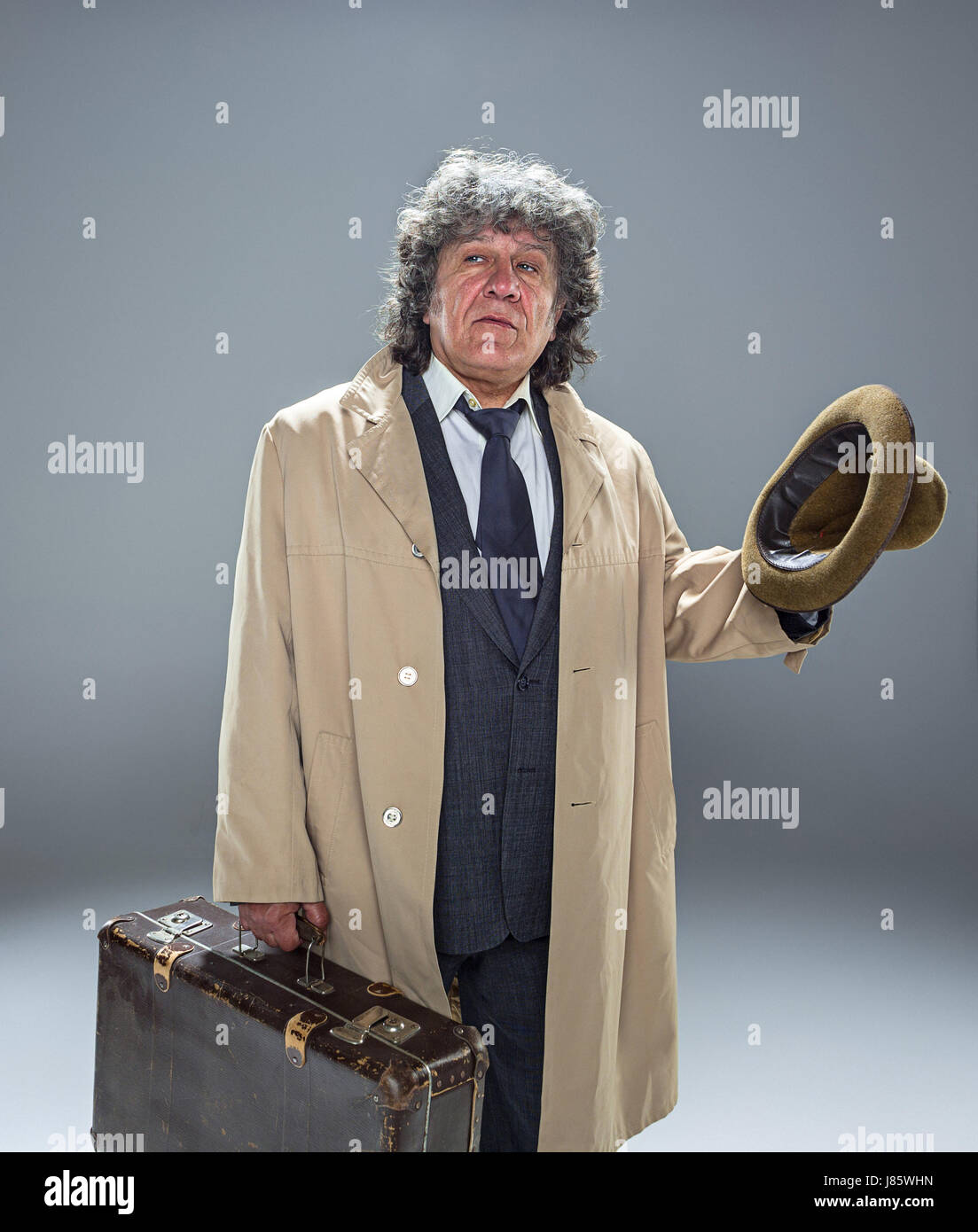 The senior man as detective or boss of mafia on gray studio background ...