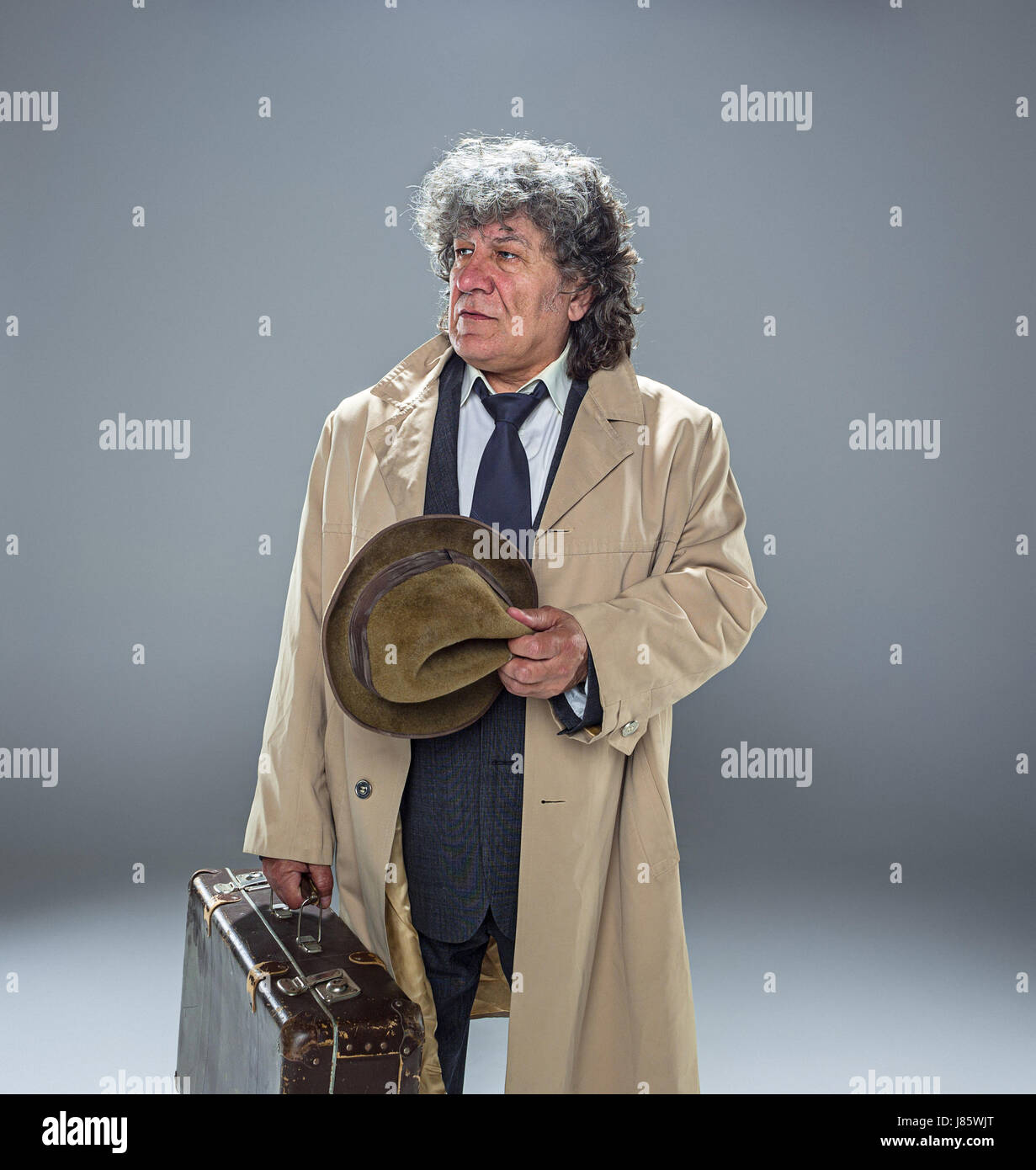 The senior man as detective or boss of mafia on gray studio background ...
