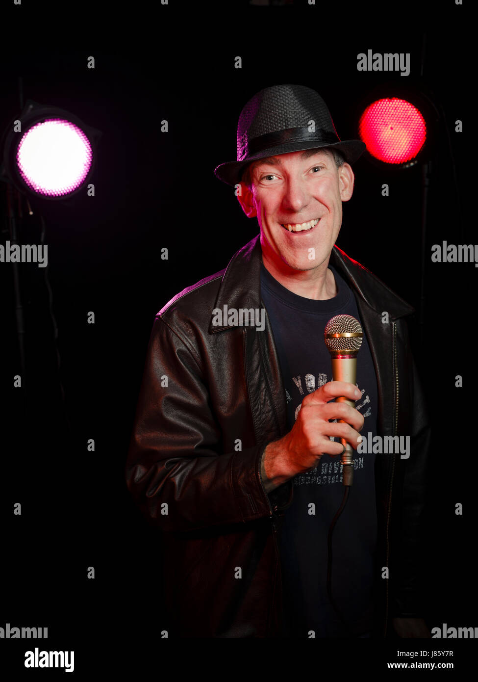 Stand-up comedian performing on stage with microphone Stock Photo - Alamy