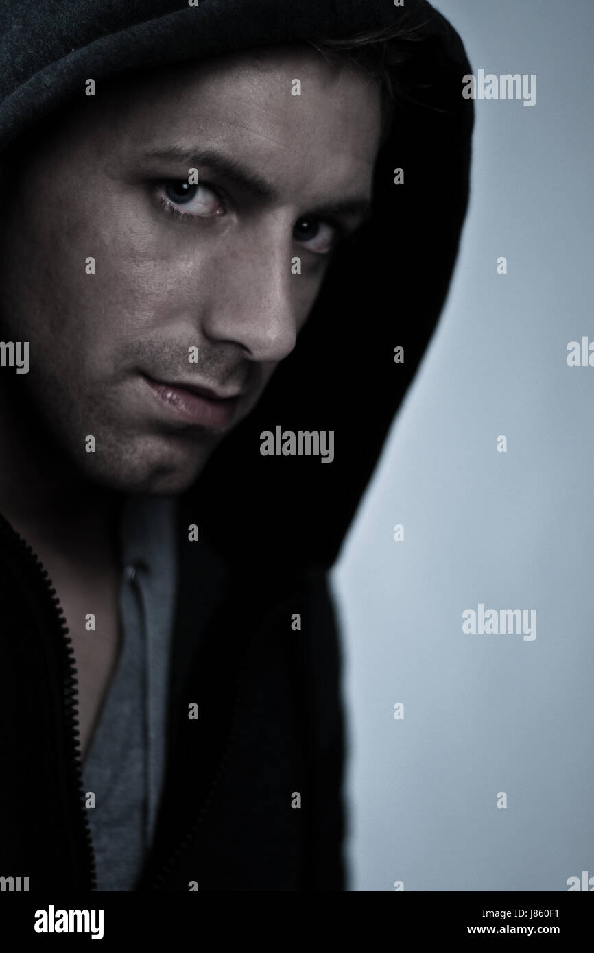 young man with intense eyes wearing a hood Stock Photo - Alamy