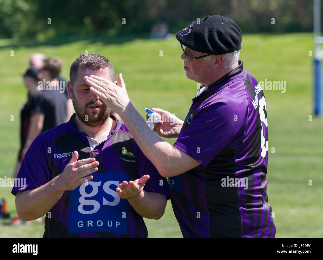 Rugby player has sun cream applied during match on a very hot, sunny ...
