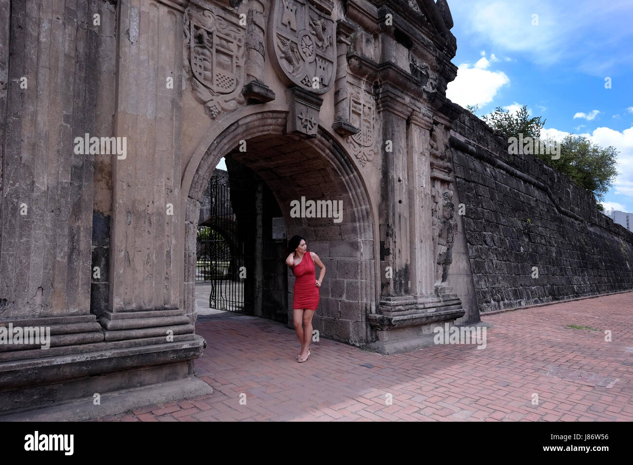 A young Filipino woman posing at the entrance to Fort Santiago a ...