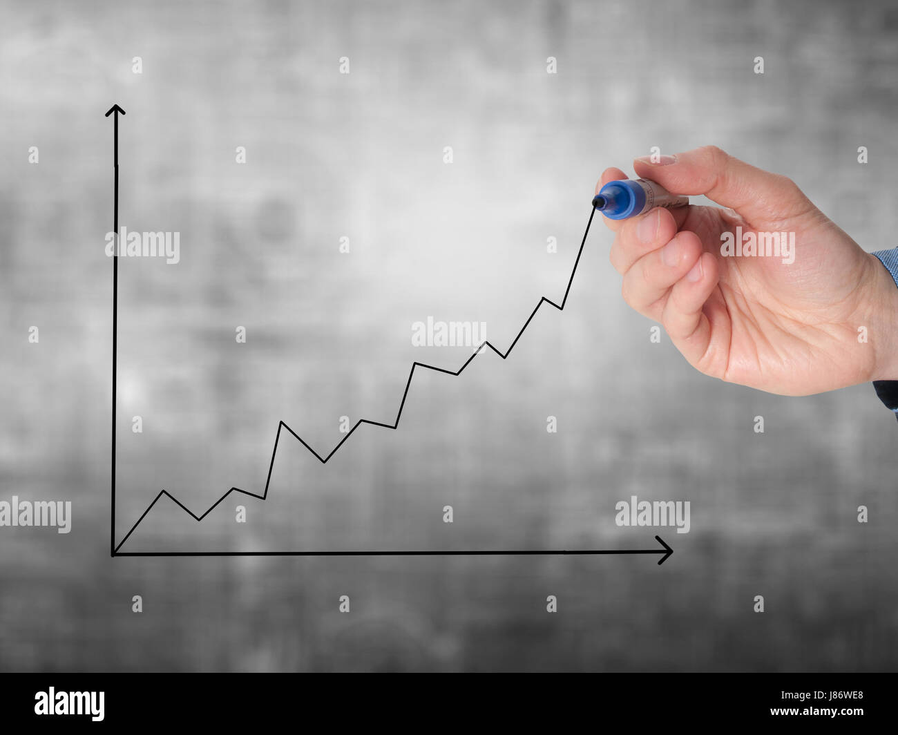 Business man drawing a growing graph. Isolated on grey. Growth concept ...