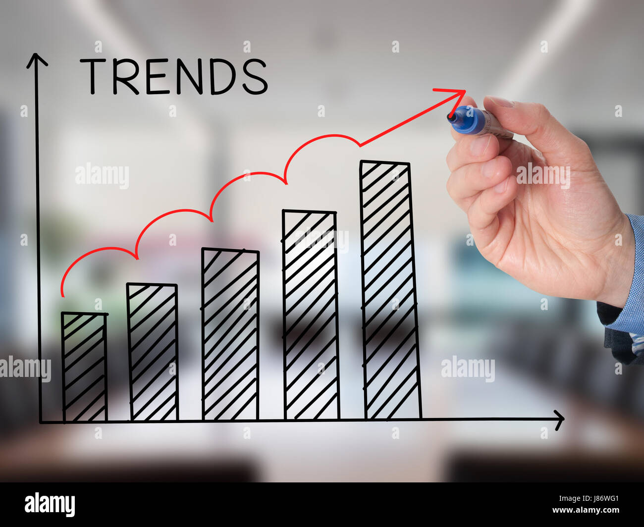 Businessman hand drawing growth trends chart isolated on office ...