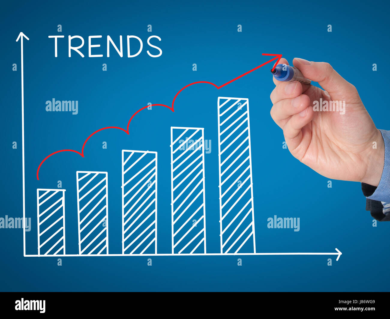 Businessman hand drawing growth trends chart isolated on blue ...