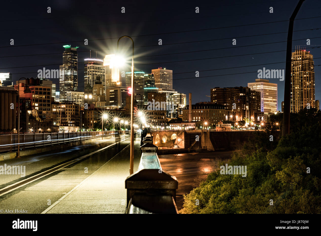 Night time at the Stone Arch Bridge in Minneapolis with the skyline at ...