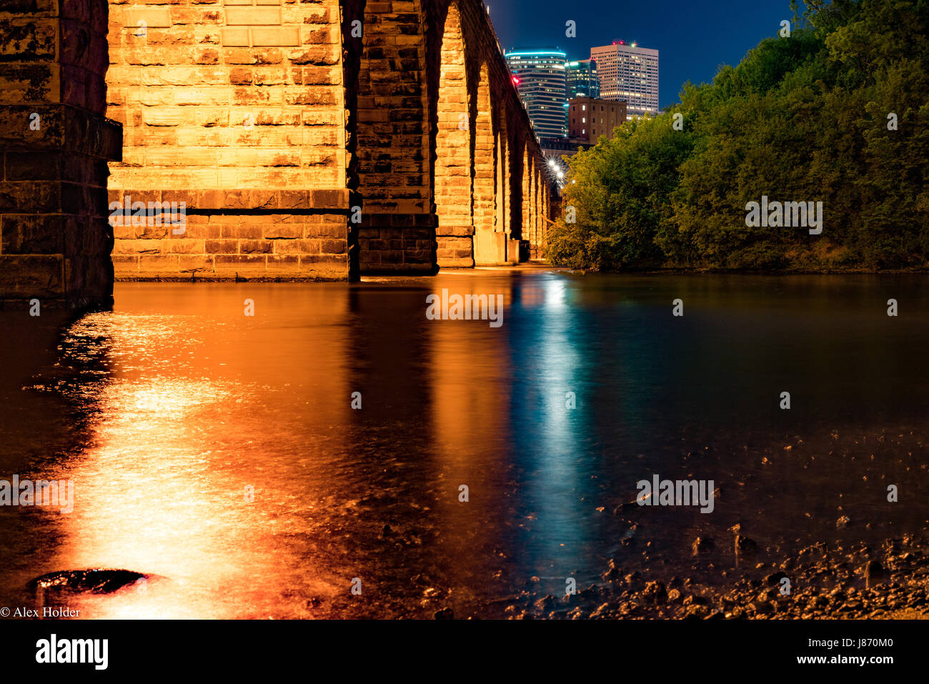Night time at the Stone Arch Bridge in Minneapolis with the skyline at ...