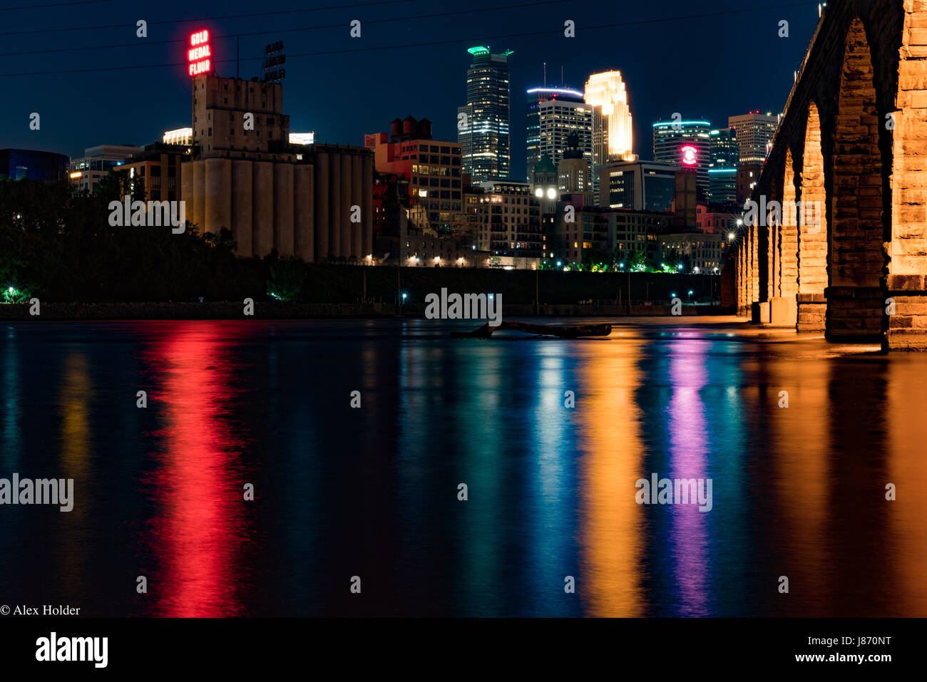 Night time at the Stone Arch Bridge in Minneapolis with the skyline at ...