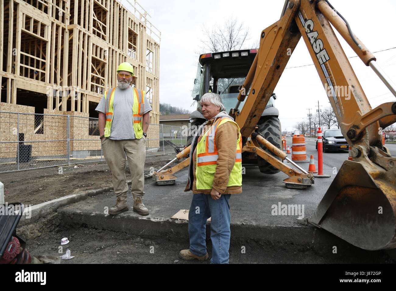 Construction workers (one in hard hat) working on a building. Heavy ...