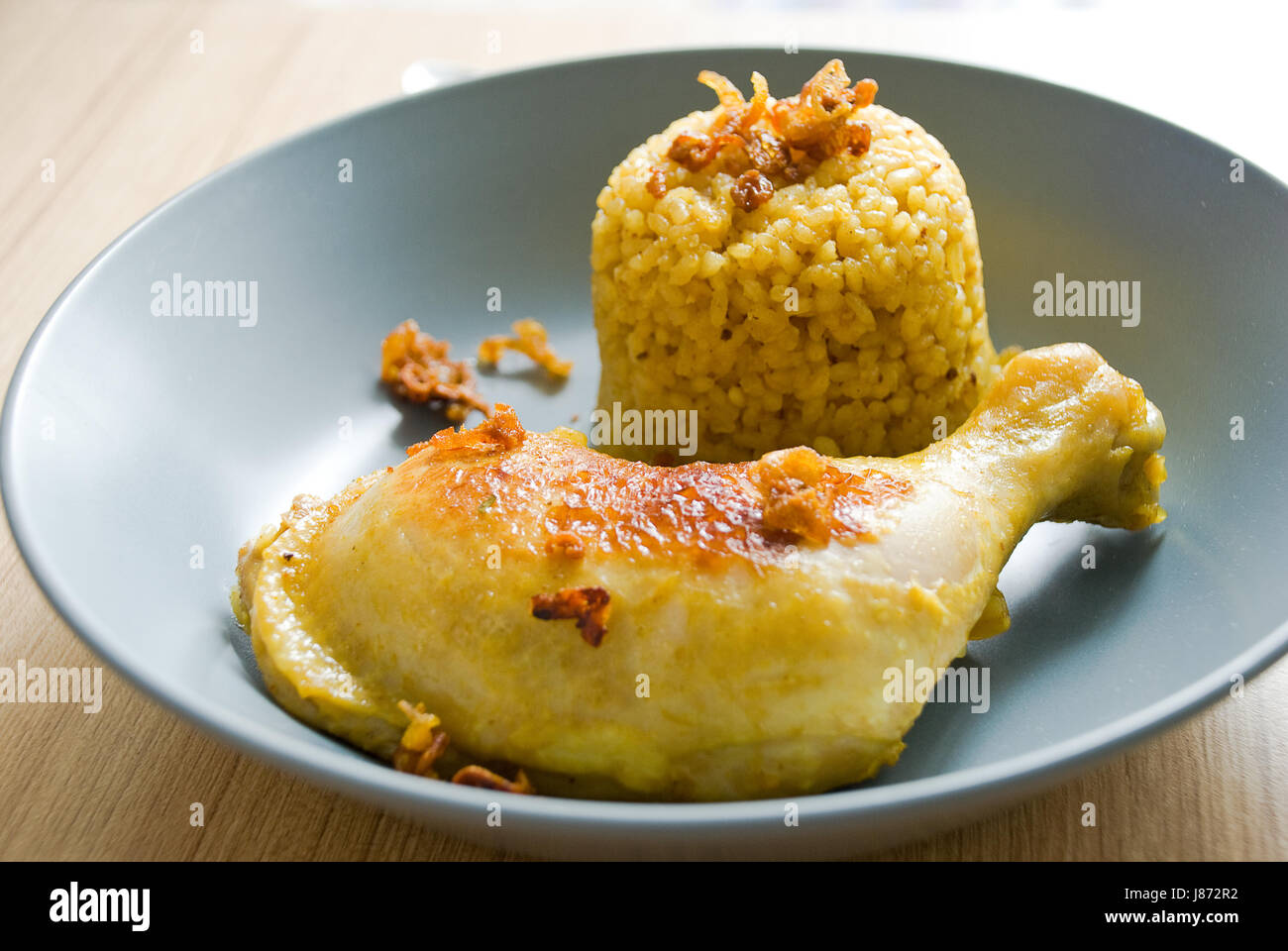 Yellow rice with fried Chicken on blue plate Stock Photo - Alamy