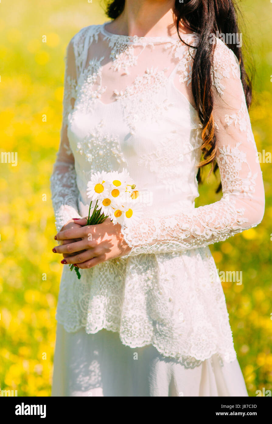 Wedding bouquet of daisies in the hands of the bride. Wedding in ...