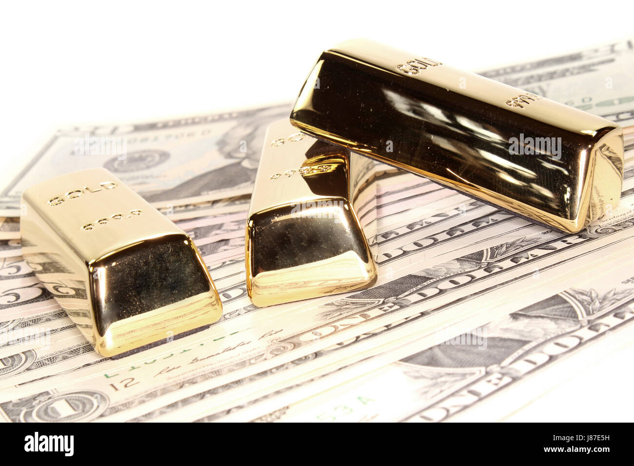 three large gold bars on dollar bills Stock Photo - Alamy