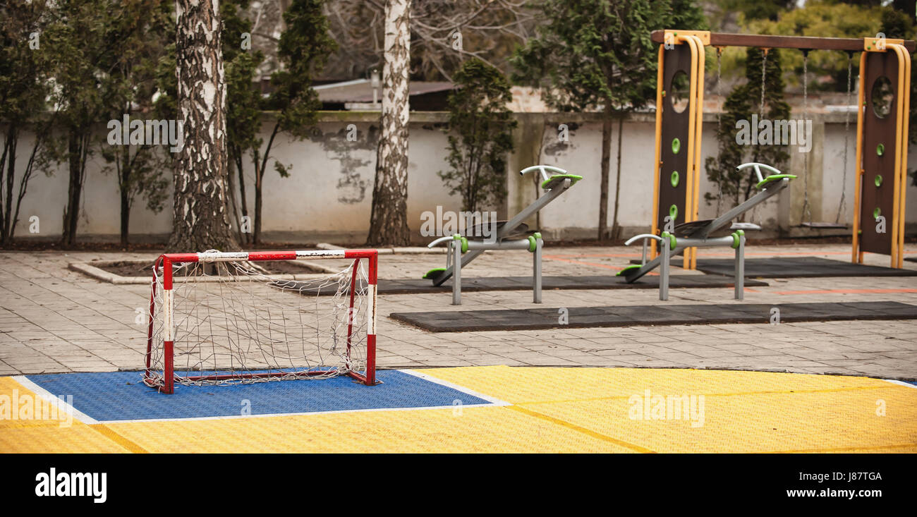 Children playground yard with soccer football goal, swings and seesaws ...