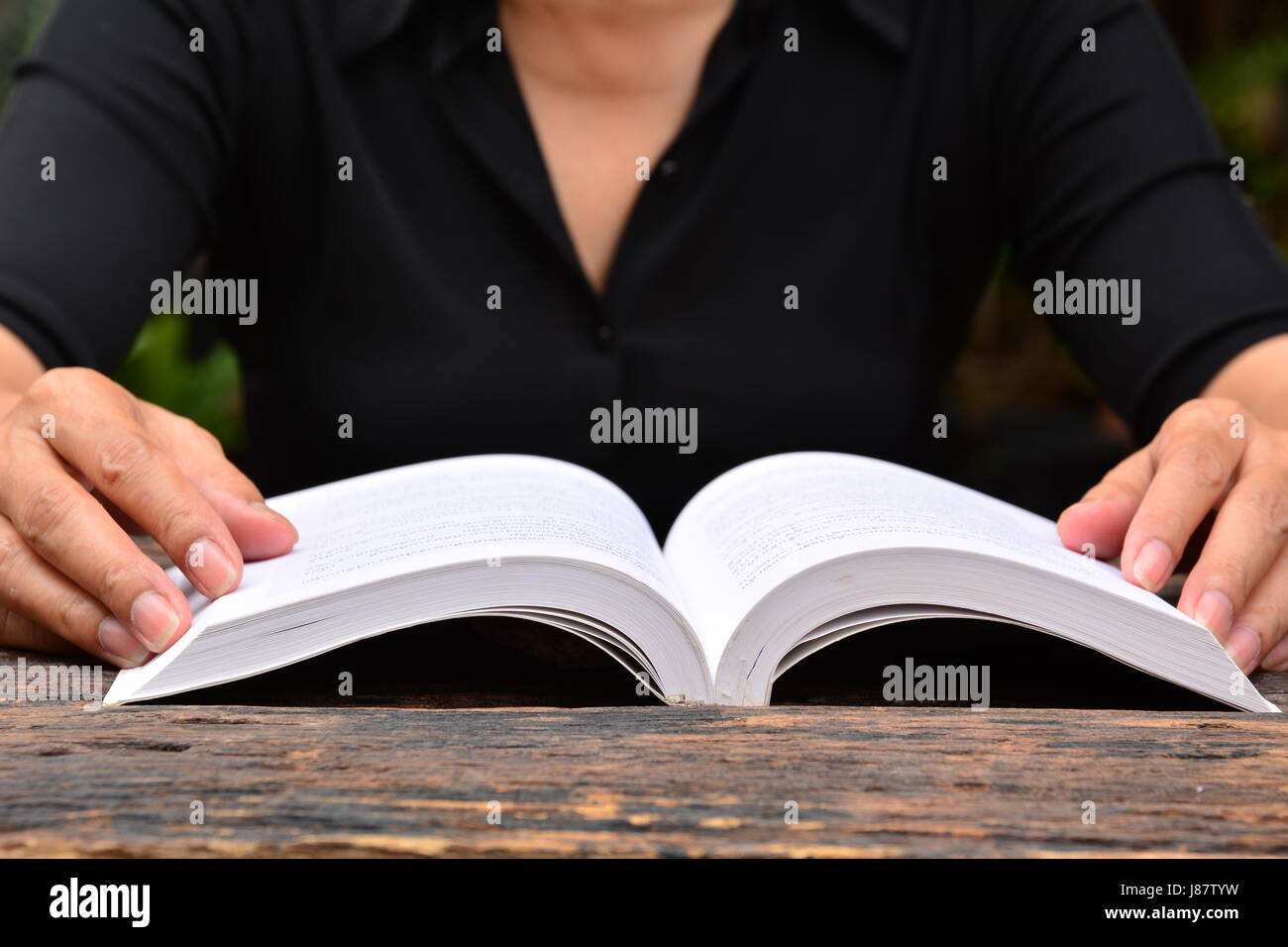 person read the book on wooden table Stock Photo - Alamy