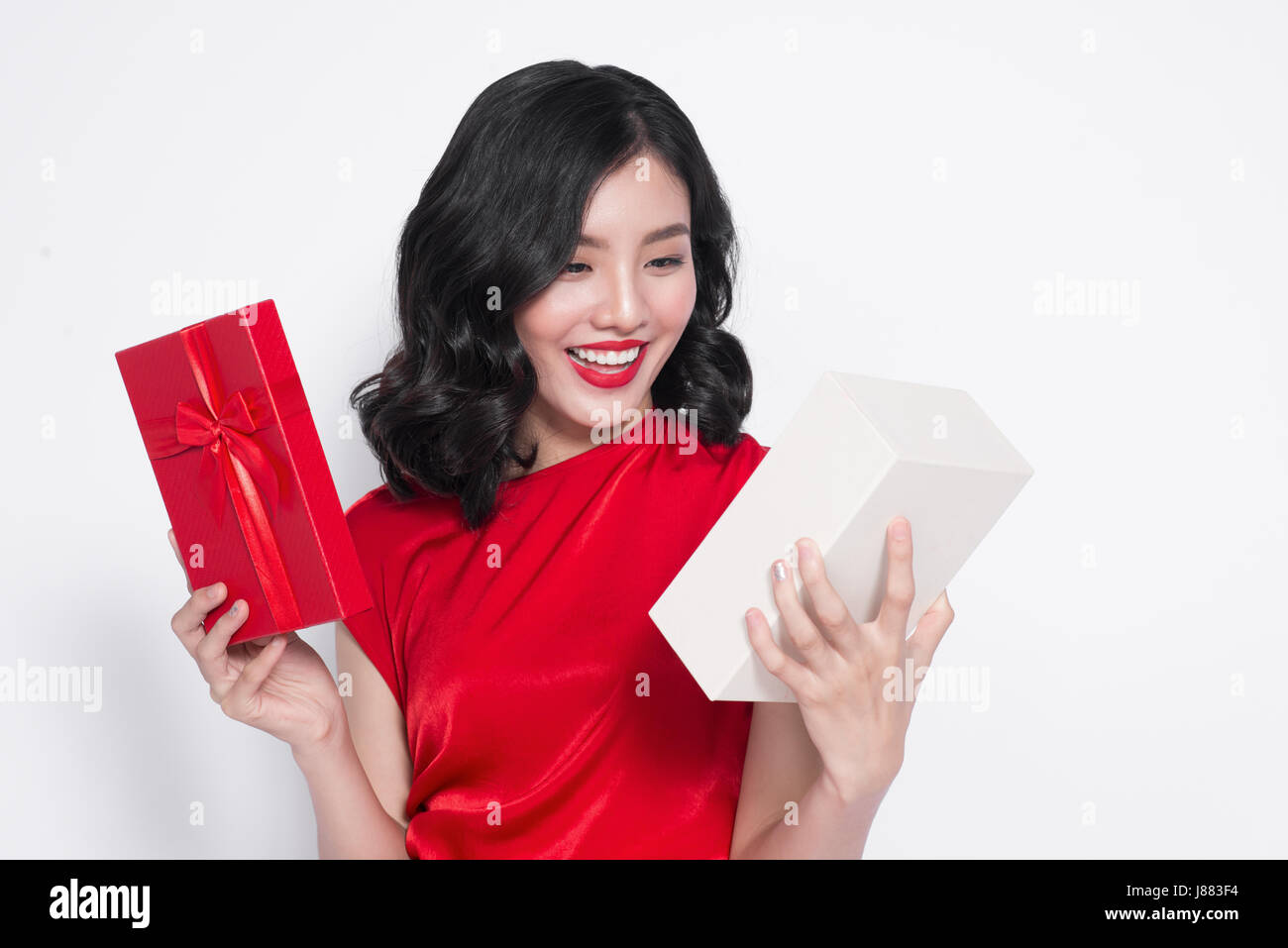 Pretty young asian woman dressed in red dress with a present Stock ...