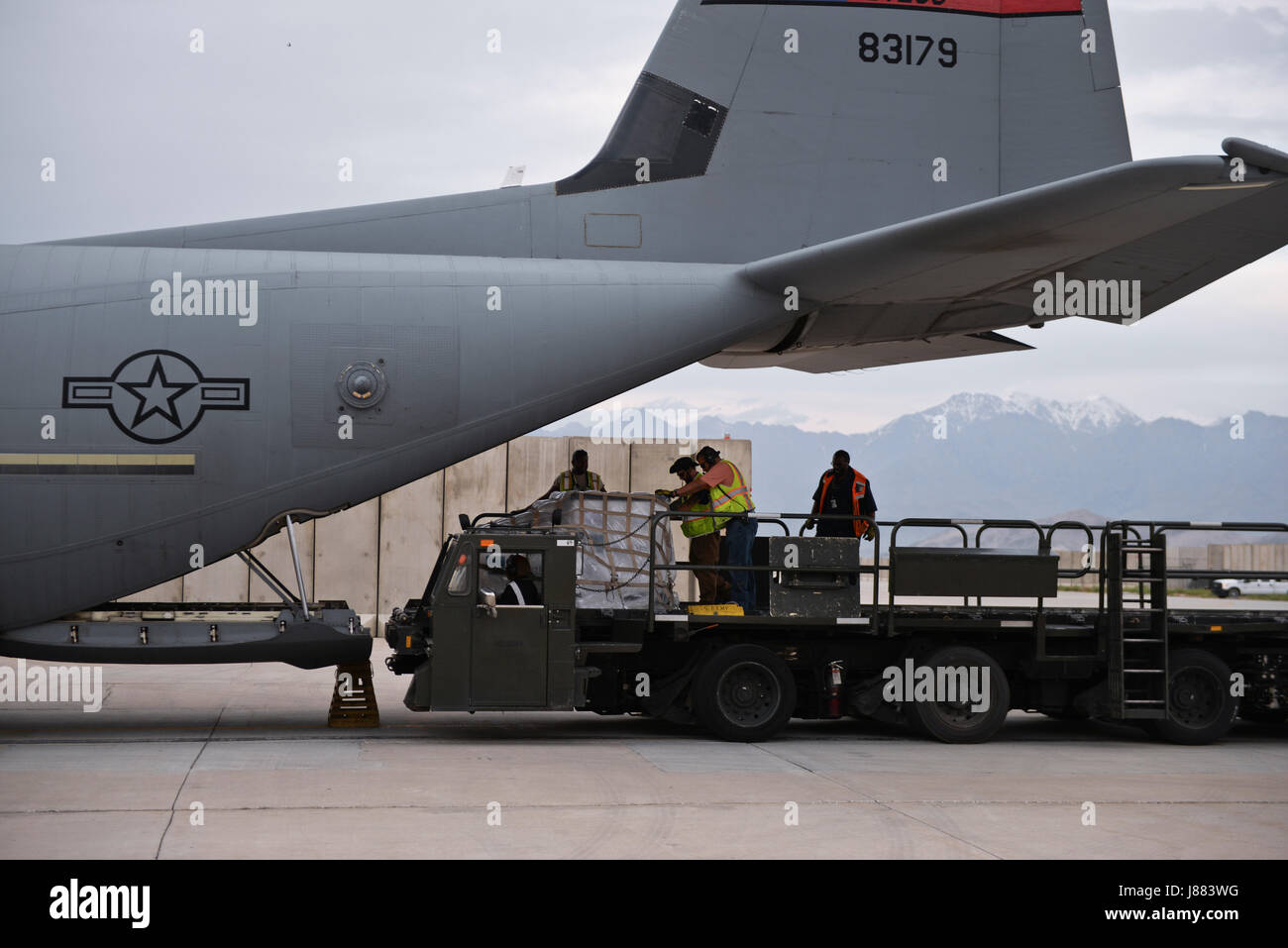 Civilian contractors load cargo onto a C-130J Super Hercules at Bagram ...