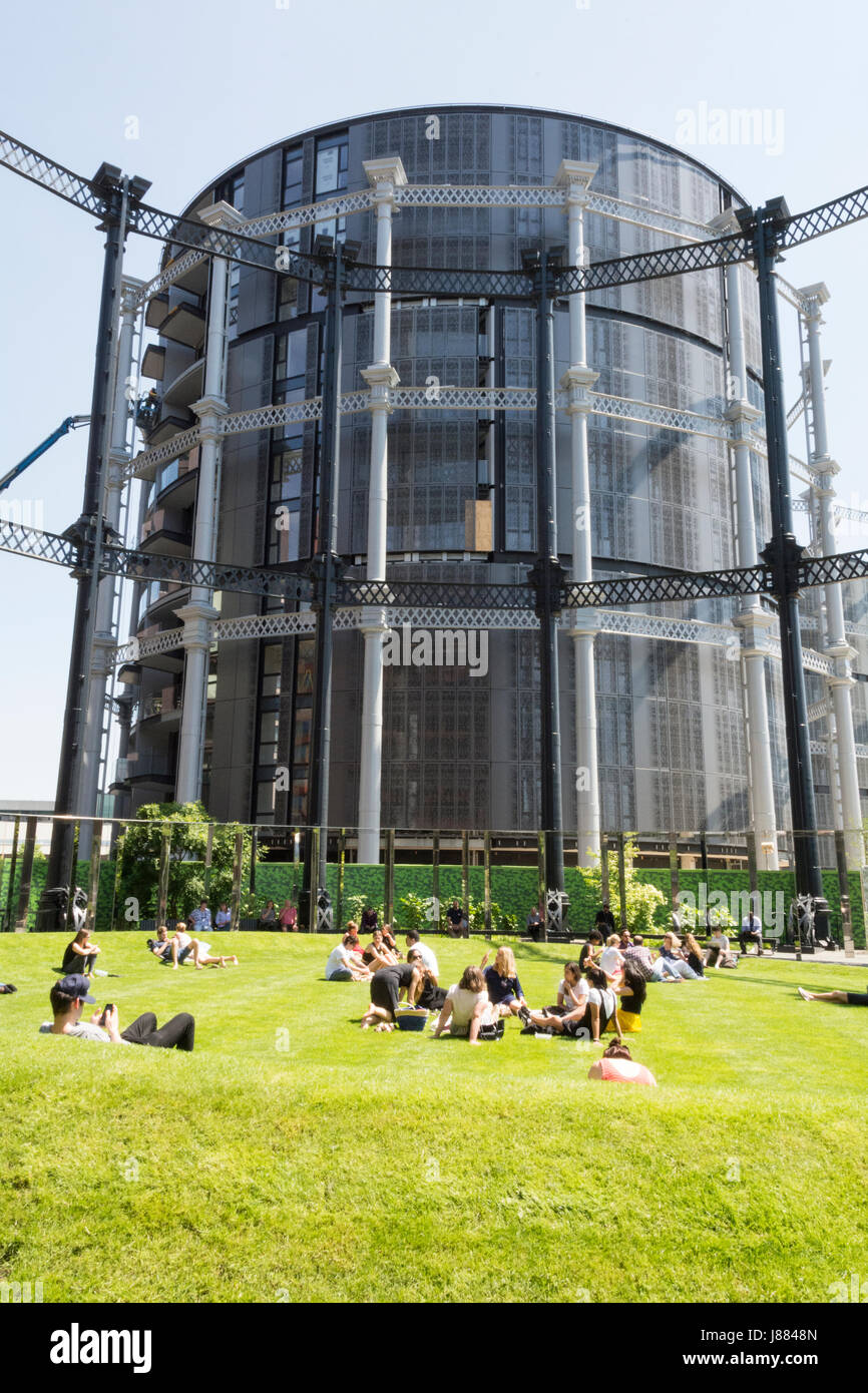 People relaxing at lunchtime in Gasholder Park in King's Cross, London ...