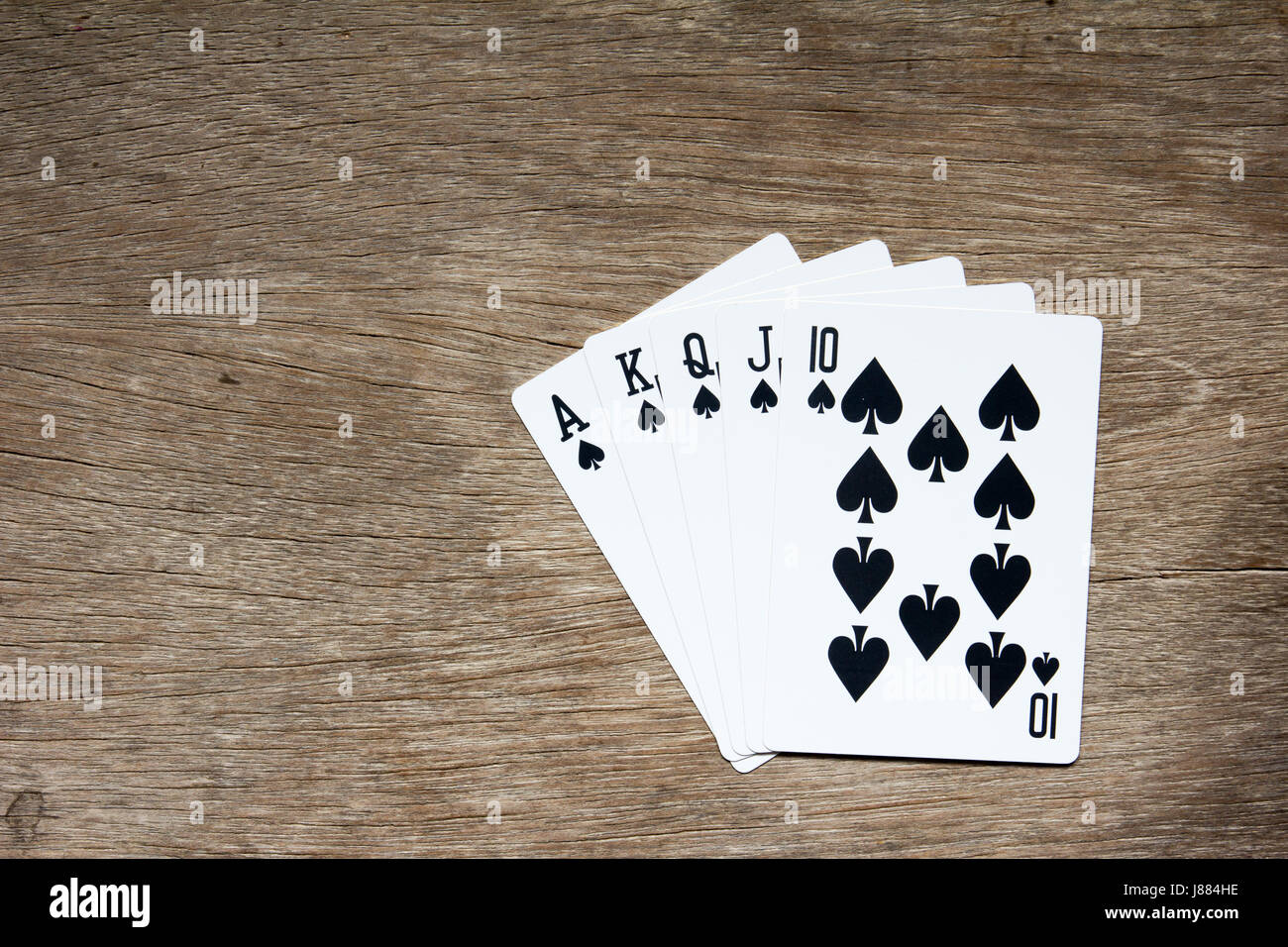Five card of black spade royal straight flush on wooden background ...