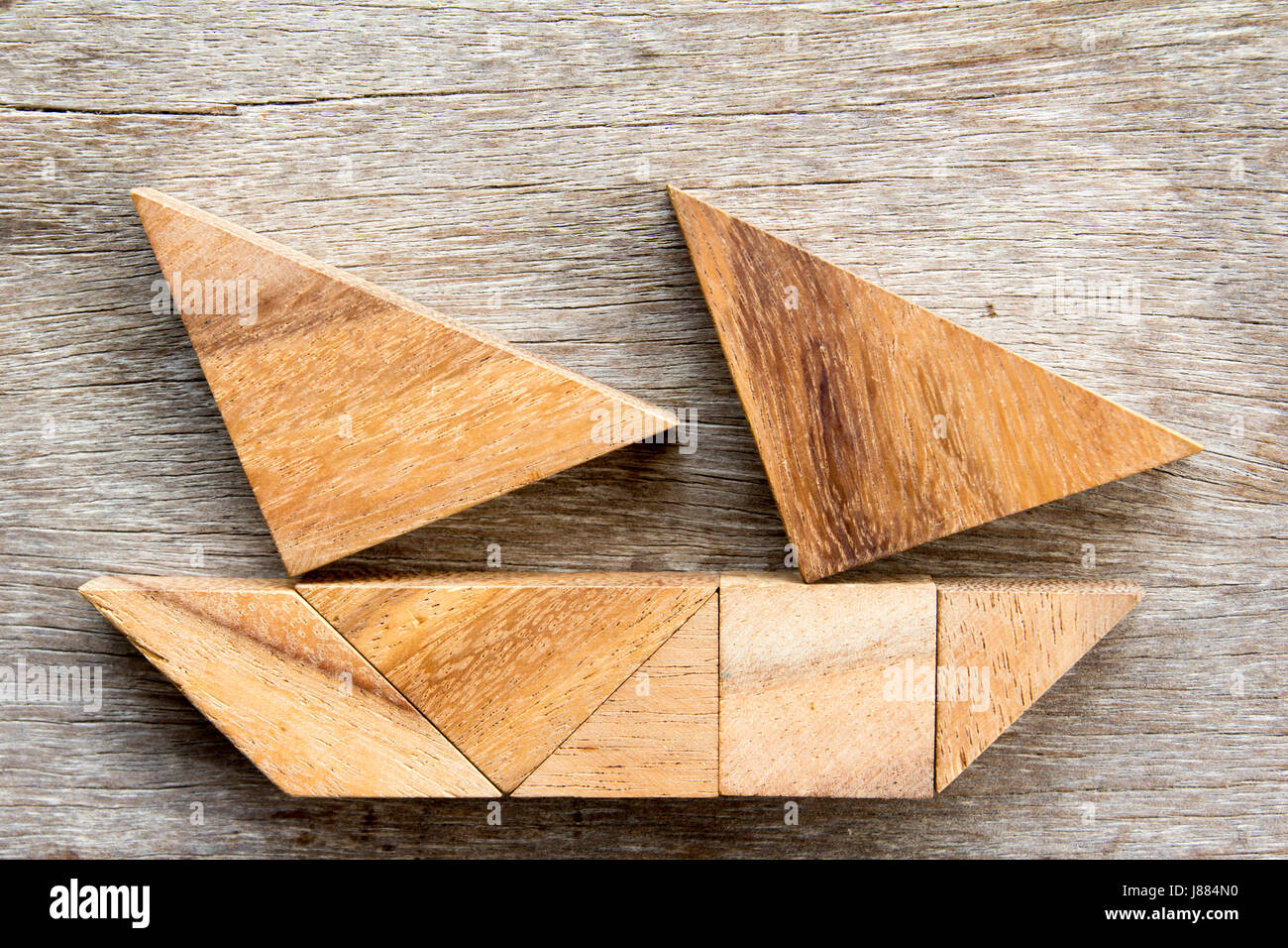 Tangram puzzle in sailing boat on wooden background (Concept for start ...