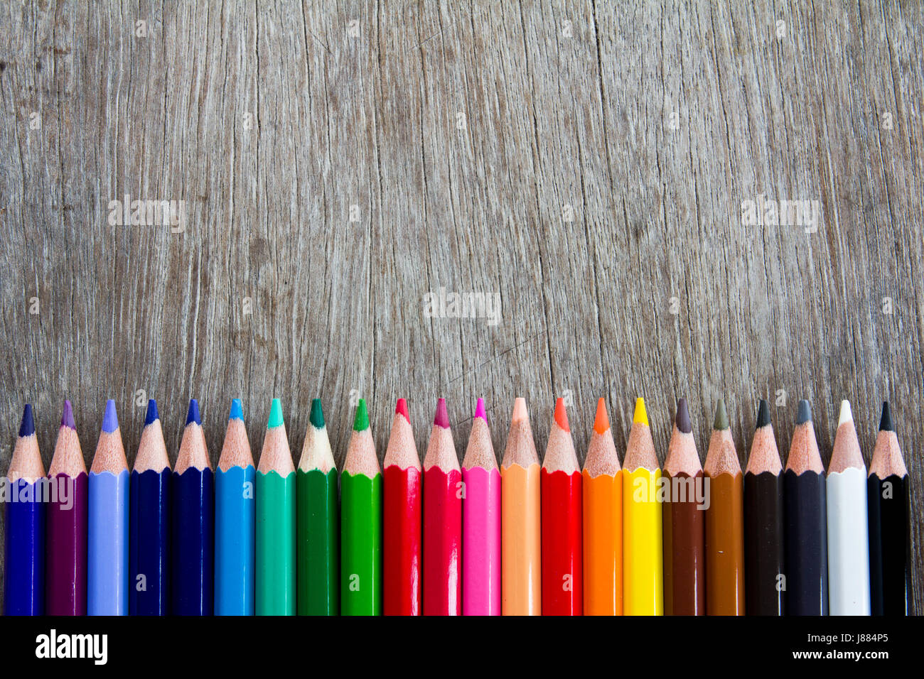 Color pencil row on the wooden background Stock Photo - Alamy