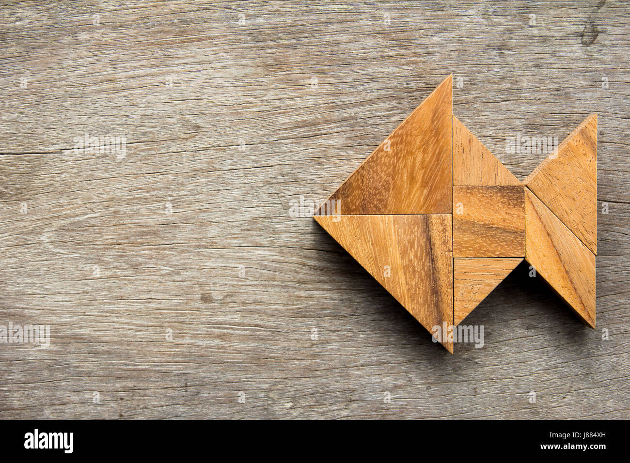 Chinese tangram puzzle in fish shape on wooden background Stock Photo ...