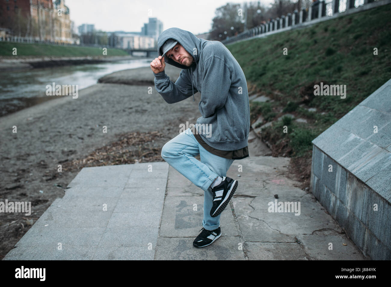 Male rapper posing on the street, urban dancing. Modern dance style ...