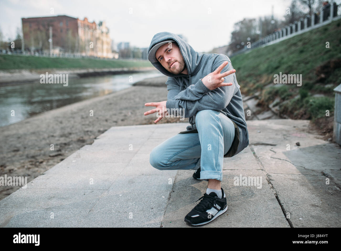 Male rapper posing on the street, urban dancing. Modern dance style ...