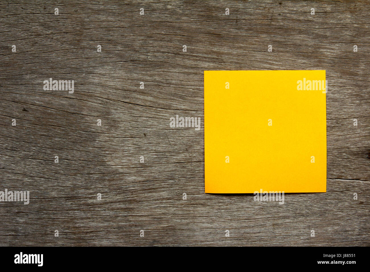 Blank orange note paper attach on brown wooden background for memo or ...