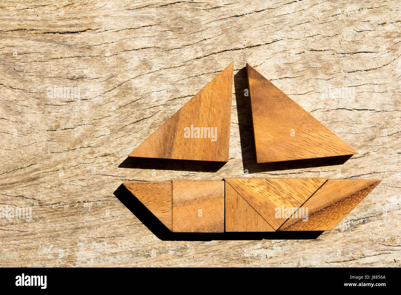 Tangram puzzle in sailing boat on wooden background (Concept for start ...