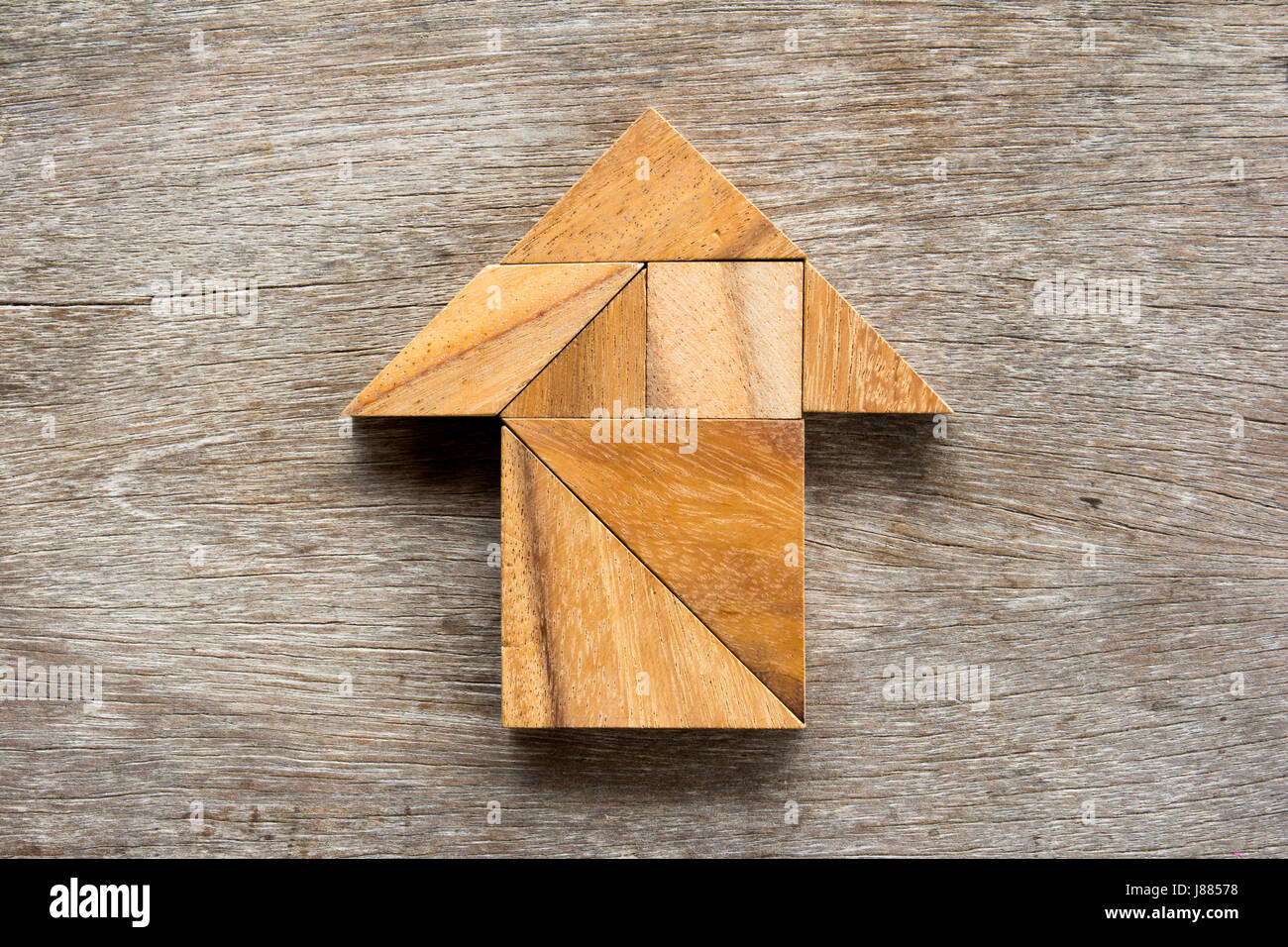 Tangram puzzle in arrow shape on wooden background Stock Photo - Alamy