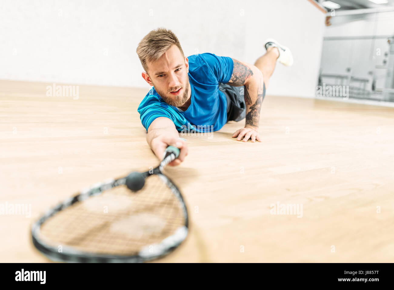 Squash training, male player with racket lies on the floor. Active ...