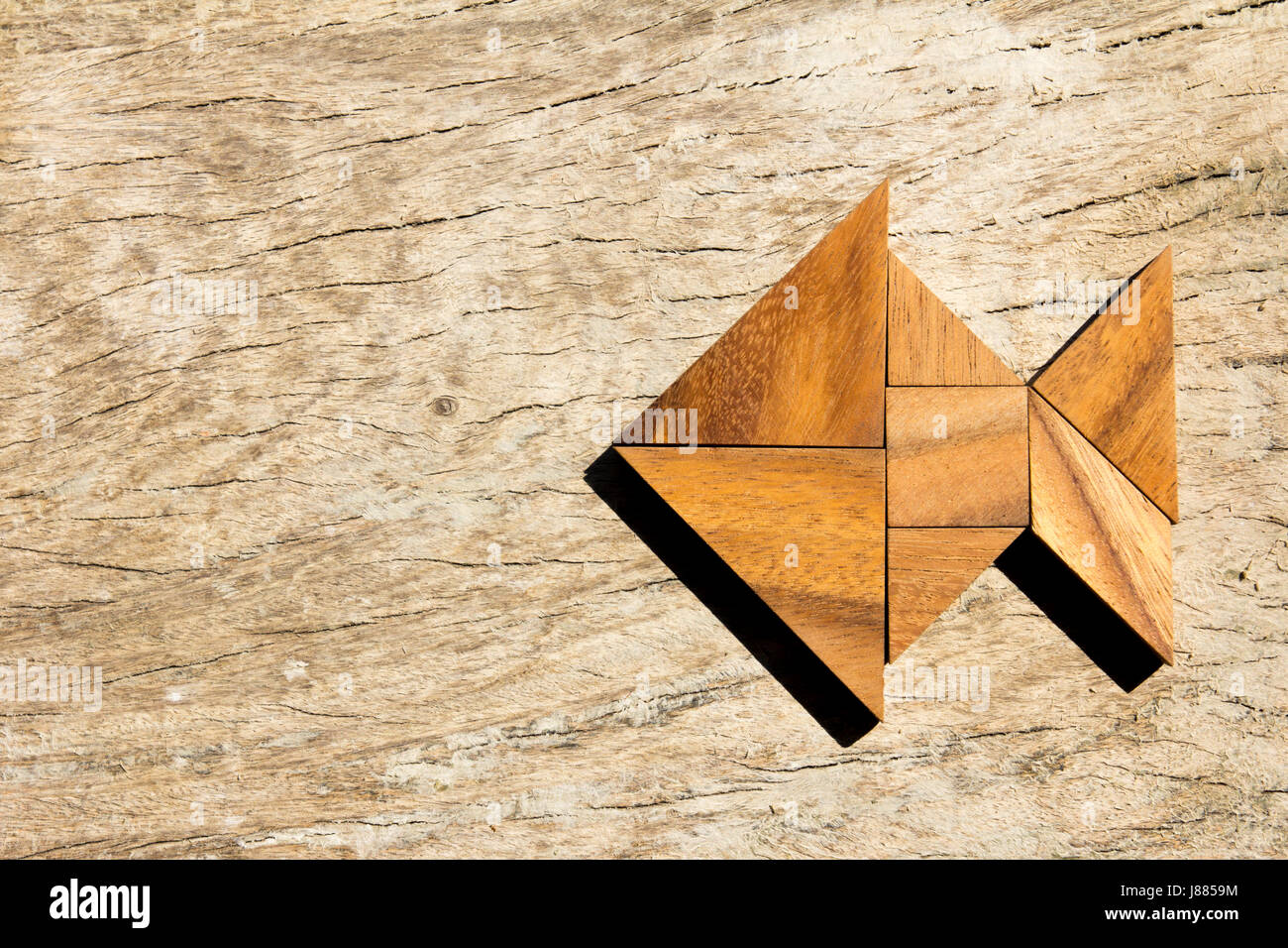 Wooden tangram puzzle in fish shape with copy space background Stock ...