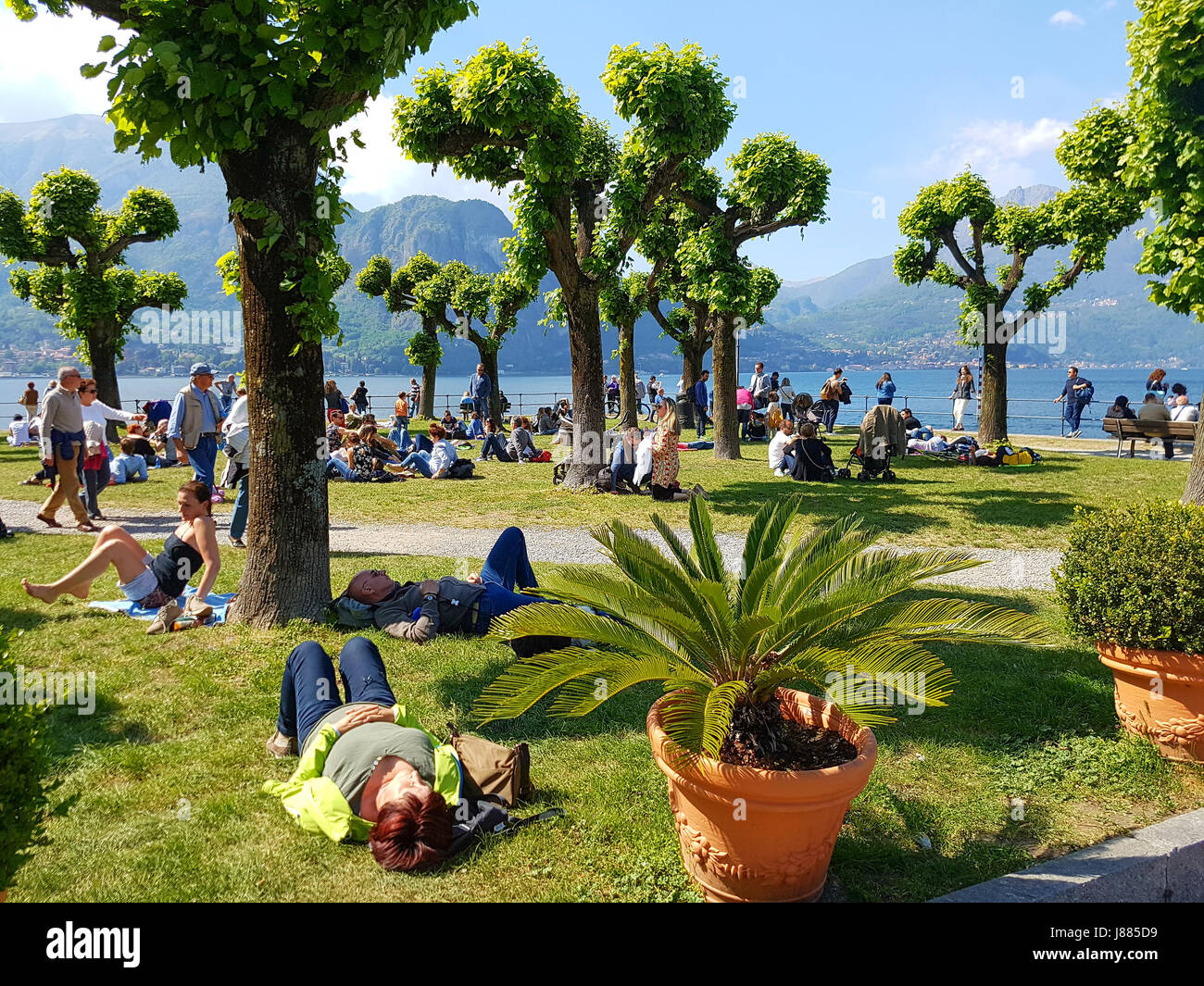 BELLAGIO, ITALY- APRIL 23, 2017: Unknown tourists lying on the grass by ...
